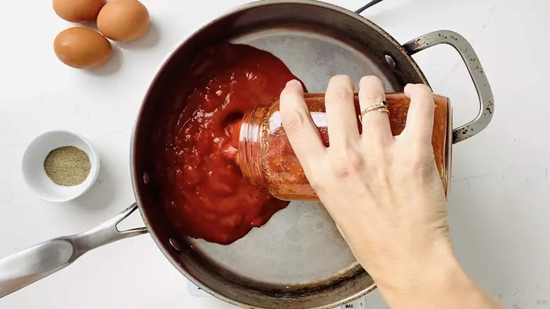 versando il sugo di pasta nella padella