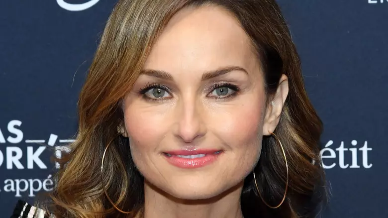 Giada De Laurentiis hymyilee punaisella matolla