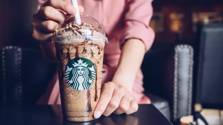 Лице што држи Starbucks Frappuccino