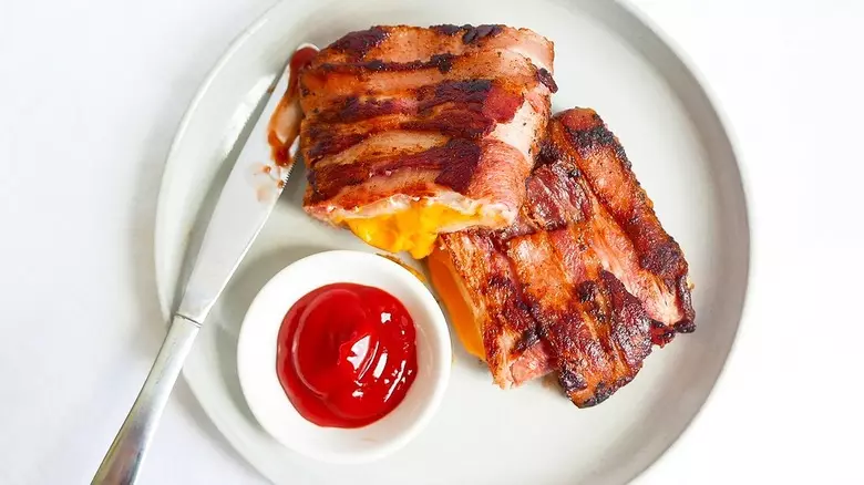 El formatge de cansalada a la planxa es troba en un plat amb salsa de tomàquet