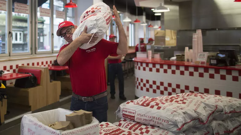 Medewerker Five Guys draagt aardappelen