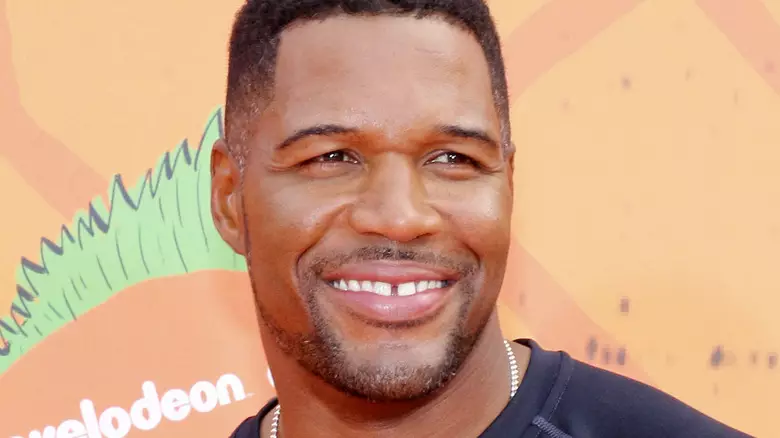 Ο Michael Strahan χαμογελά με μαύρο πουκάμισο