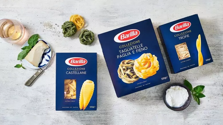 Caixas de pasta Barilla sobre mostrador con sal e queixo