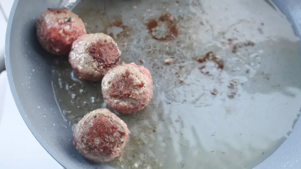 Köttbullar som lagar mat i en panna för Subway Meatball Marinara Sub copycat recept