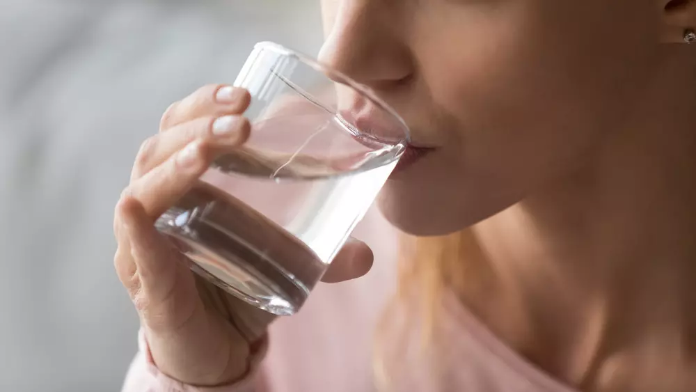 Donna che beve un bicchiere d'acqua