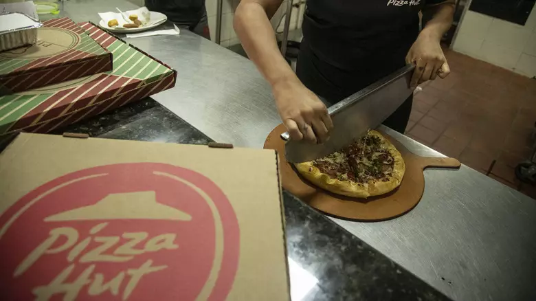Cortando a pizza da Pizza Hut