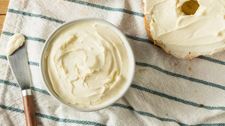 Jibini la cream na bagel kwenye kitambaa kilichopigwa