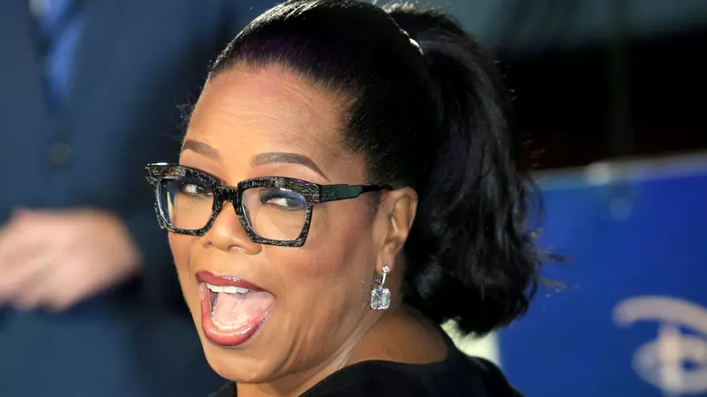 Oprah amwenyura n'umutwe uhengamye kuruhande