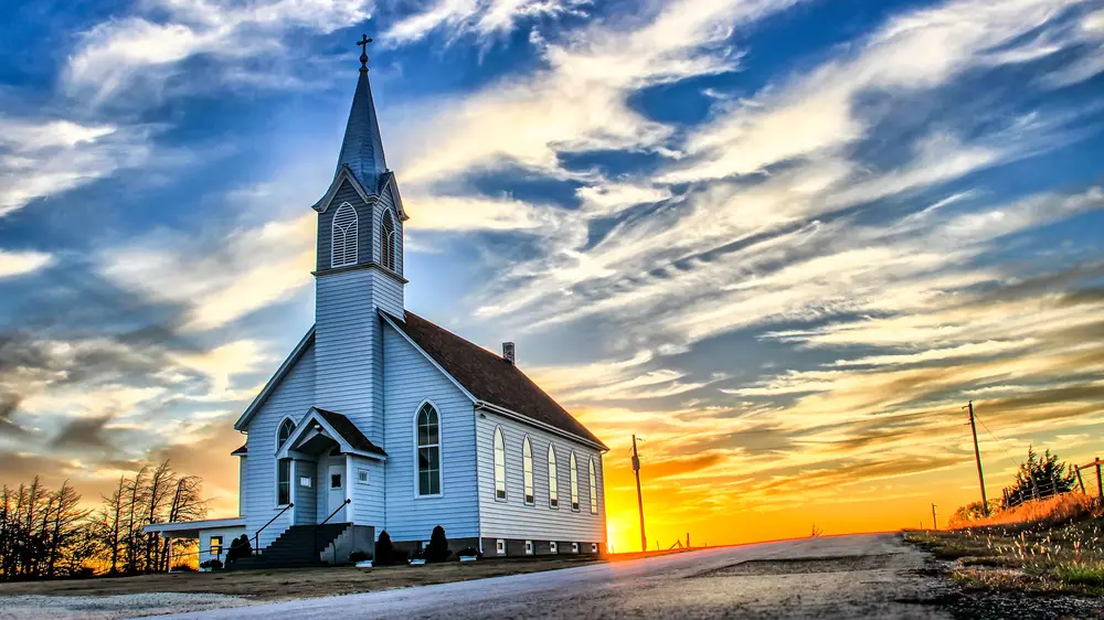 Valge kirik maapiirkonnas päikeseloojangul