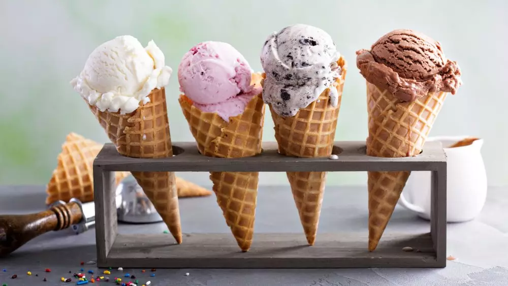 plaub ice cream scoops ntawm txawv flavors nyob rau hauv ib tug tuav