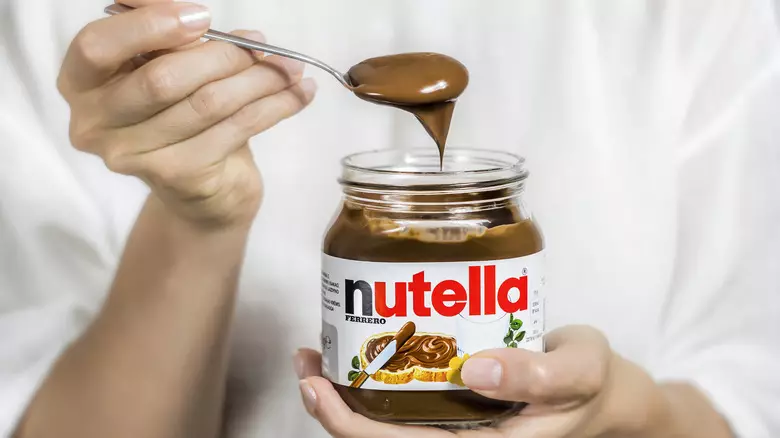 Eniyan dani idẹ ati spoonful ti Nutella