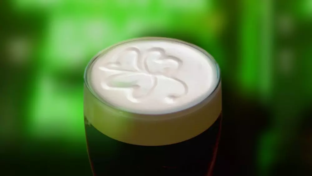 Pint ya Guinness yokhala ndi shamrock mu thovu