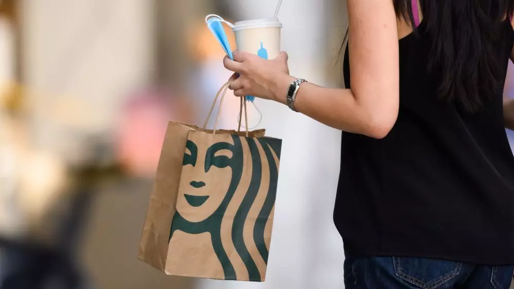 “Starbucks” sumkasyny göterýän aýal