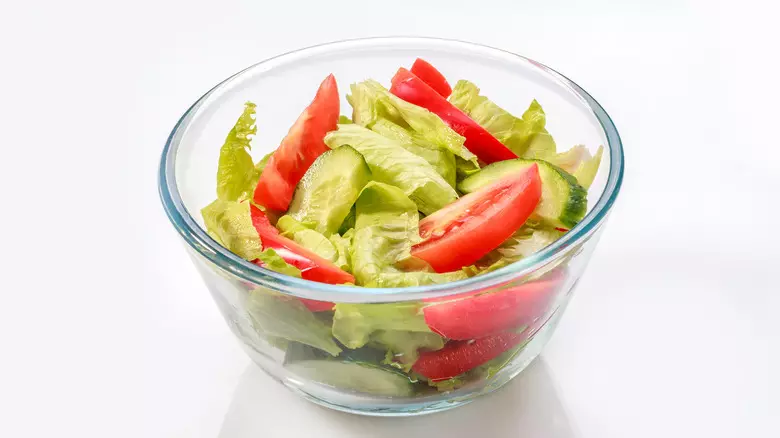 Una pequeña ensalada en un recipiente de vidrio.