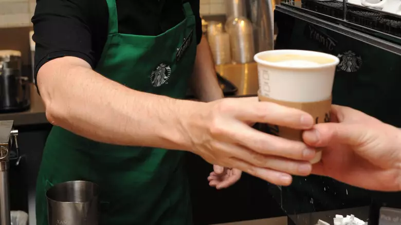 Persona, kas pasniedz latte kafejnīcā Starbucks