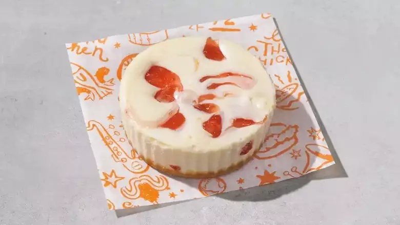 Taza de tarta de queso con fresas de Popeyes en una servilleta