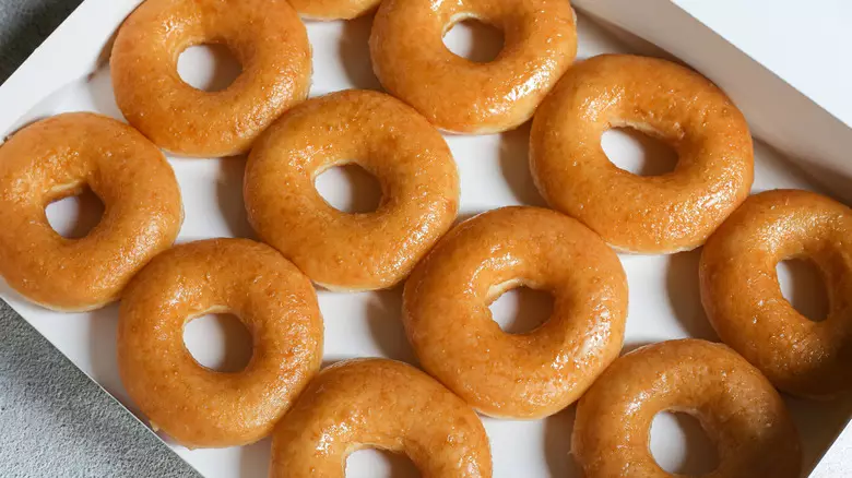 ከ Kirspy Kreme Donuts አካባቢ ውጭ ጭንብል የለበሰች ሴት