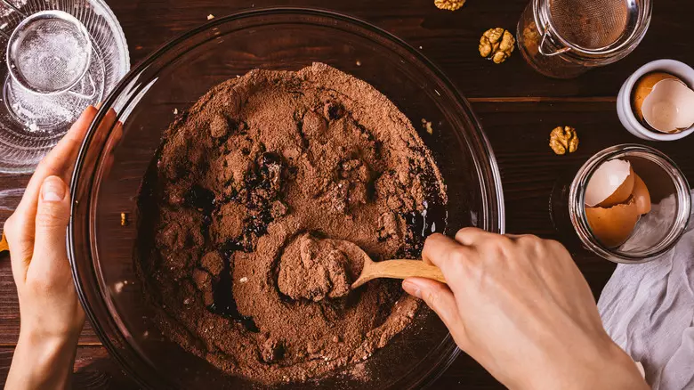 Mâinile amestecând aluatul de ciocolată