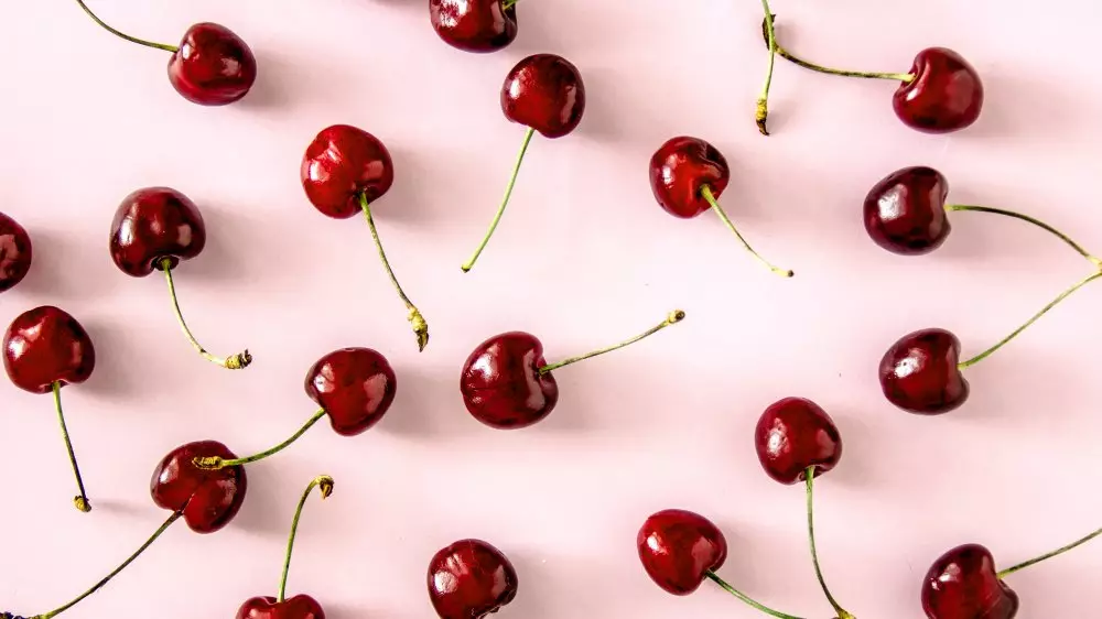 cerezas sobre un fondo rosa claro