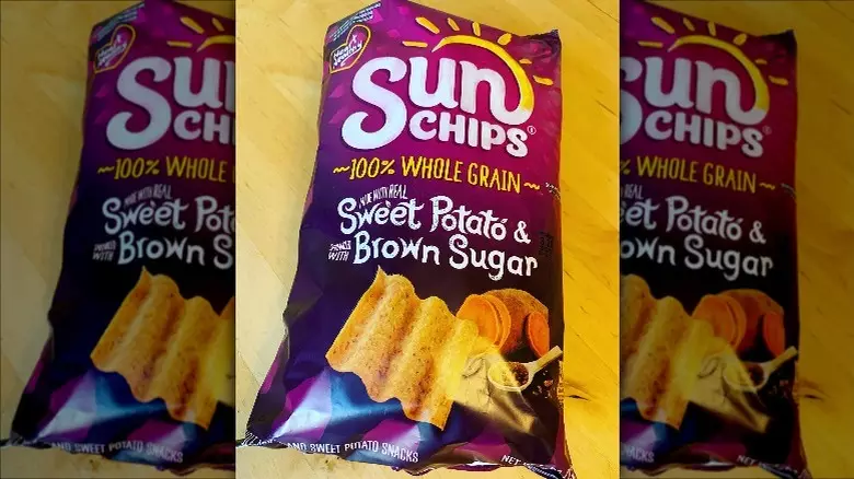 zacskó édesburgonya és barna cukor Sun Chips halvány fából készült asztal