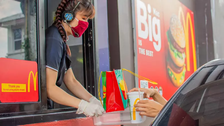 McDonald's drive thru worker hands off food