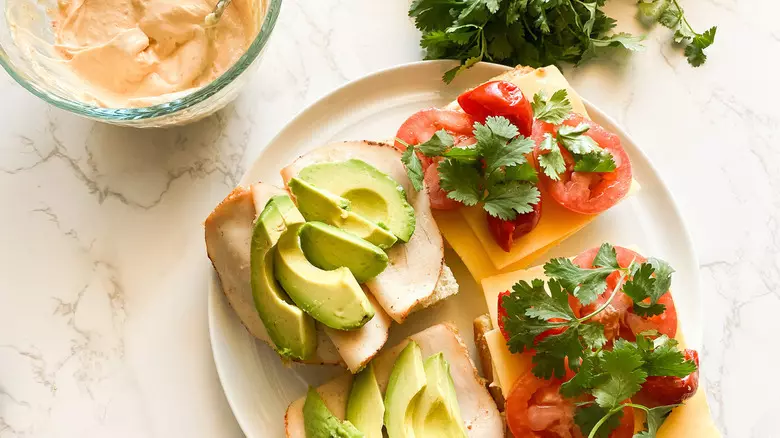 offenes chipolte-huhnsandwich mit avocado auf teller