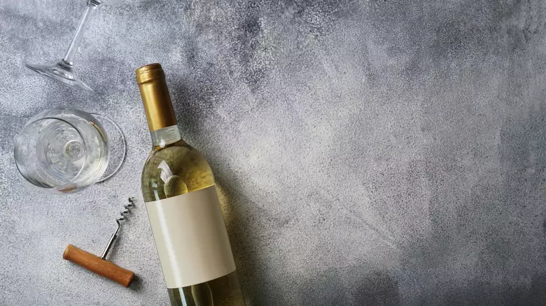 Botol wain putih di sebelah corkscrew
