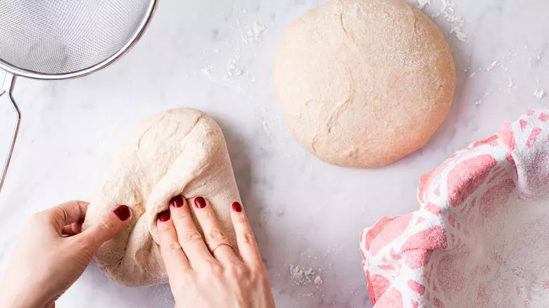 Mãos de mulher moldando a massa de pão
