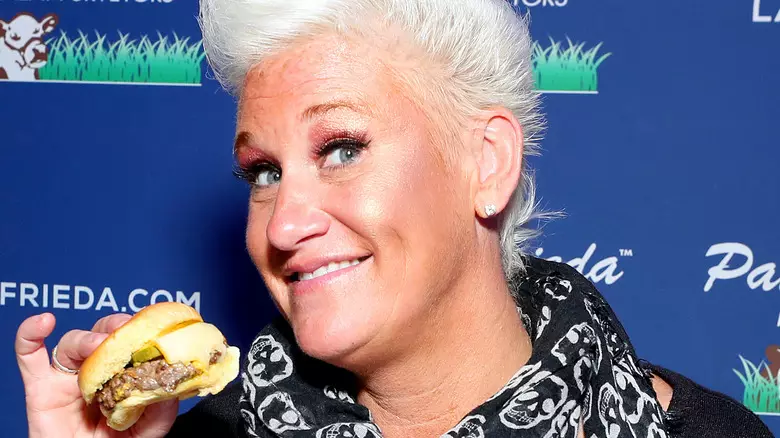 Anne Burrell ținând un cheeseburger