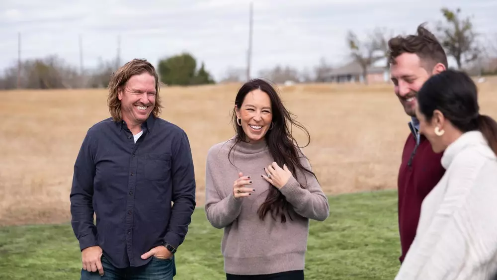 Joanna i Chip Gaines uśmiechają się w polu