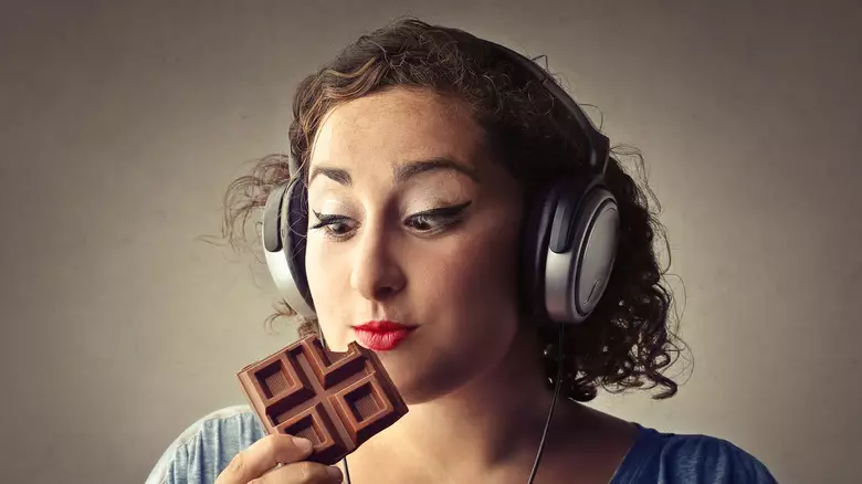 msichana kujaribu chocolate na headphones