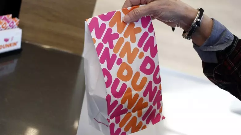 чалавек трымае сумку Dunkin' Donuts