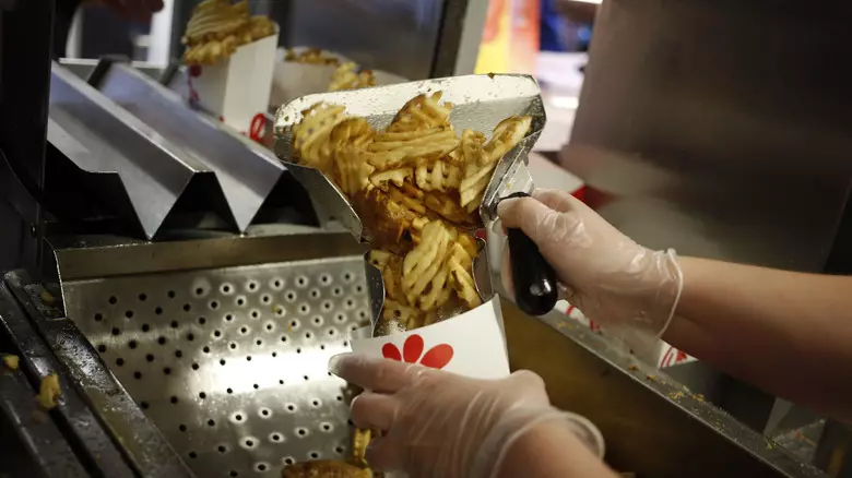 Chick-fil-співробітник наливає картоплю фрі в контейнер