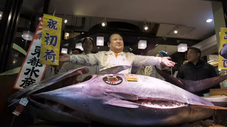 man poseert met een enorme tonijn