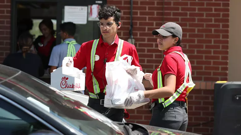 戴手套的 Chick-fil-A 員工在路邊交付取貨訂單