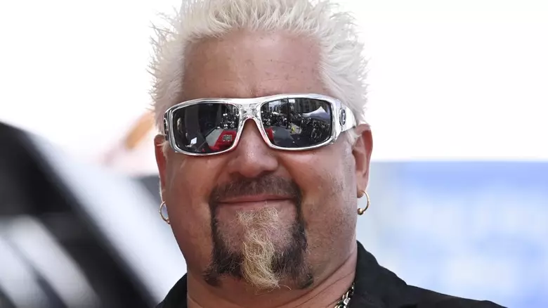 Guy Fieri souriant avec des lunettes de soleil