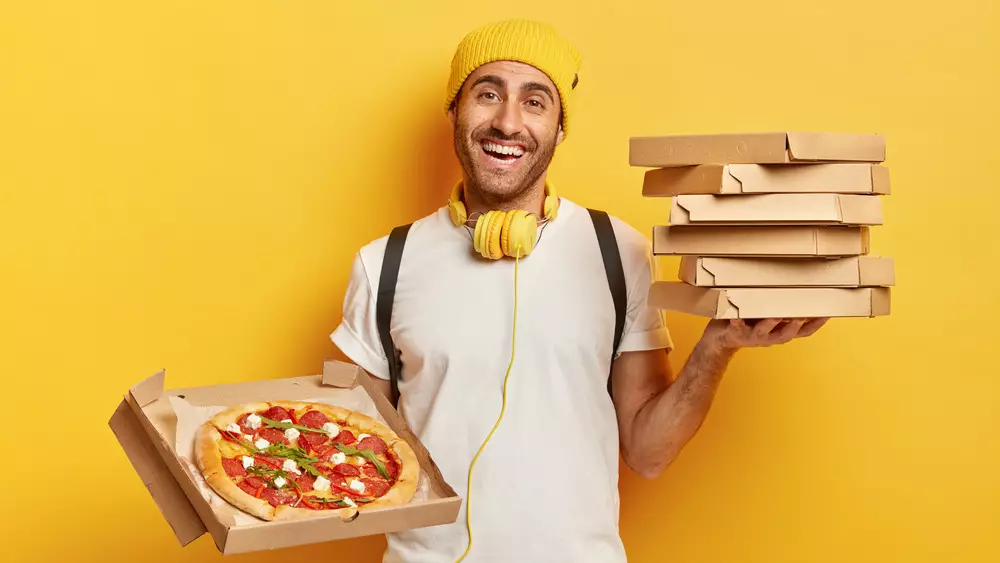 homem segurando caixas de pizza