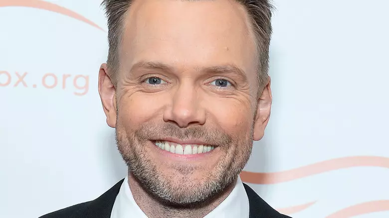 Joel McHale sorrindo no tapete vermelho