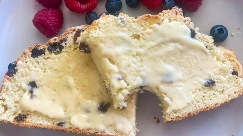 llesques de mantega de pa de refresc irlandès tradicional en un plat blanc amb nabius frescos i gerds vermells