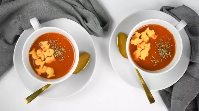 xícaras de sopa de tomate com bolachas de peixinho e pinguins