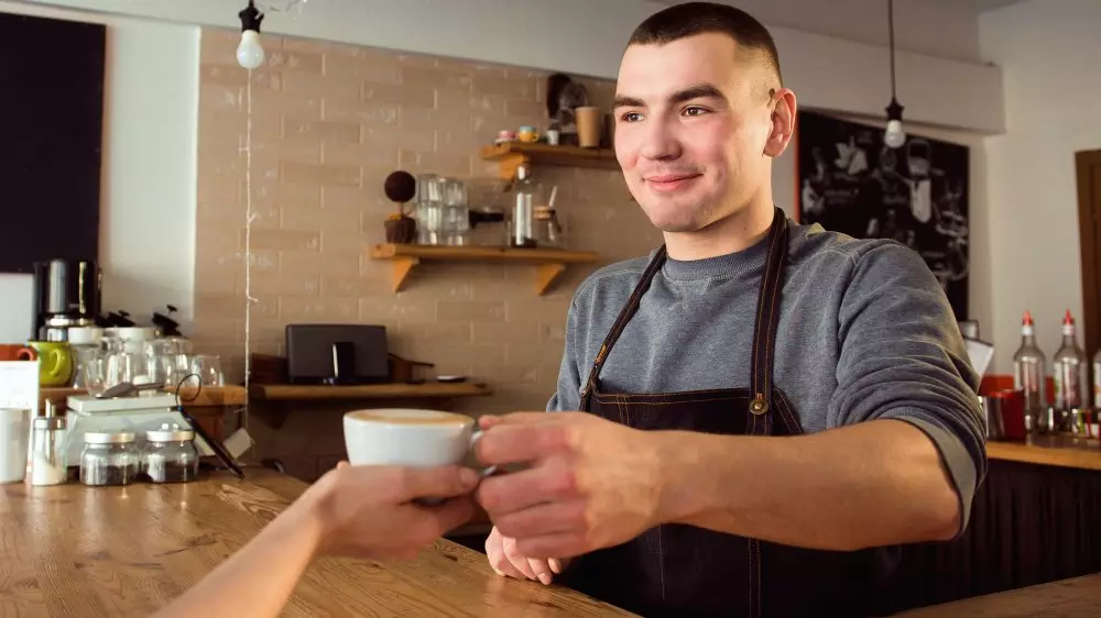 barista podáva kávu