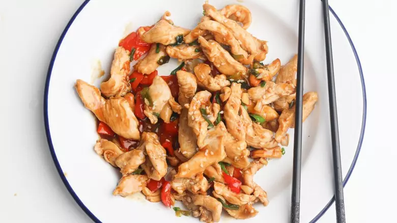 Poulet aux noix de cajou sur une assiette avec des baguettes