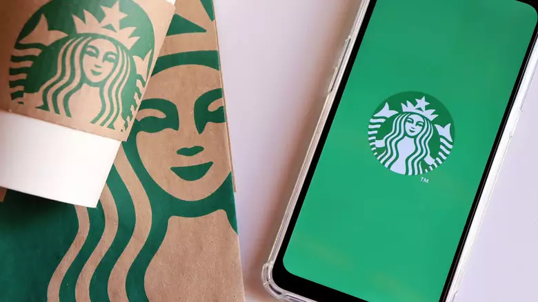 Starbucks-beker naast smartphone op tafel