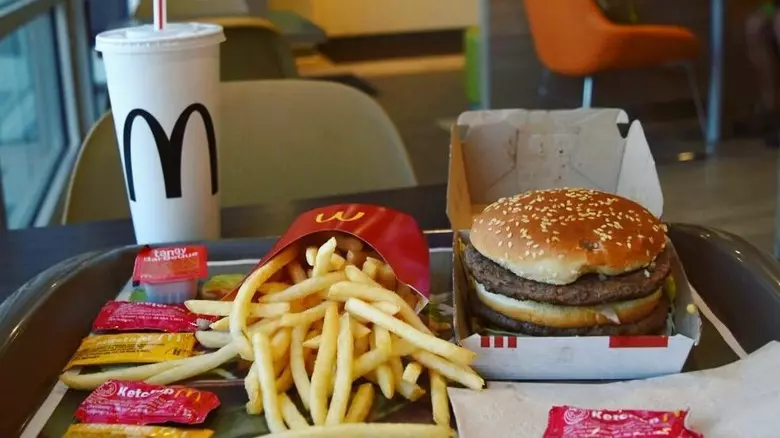 Denali Big Mac ant padėklo šalia gėrimo ir bulvyčių