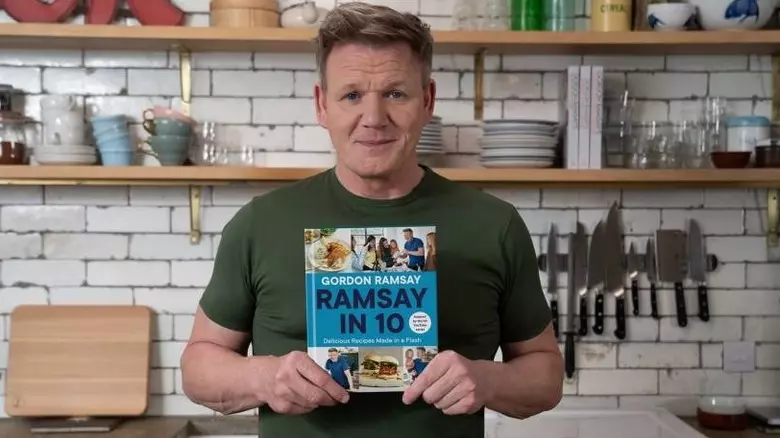 Gordon Ramsay cầm cuốn sách nấu ăn của mình Ramsay trong 10