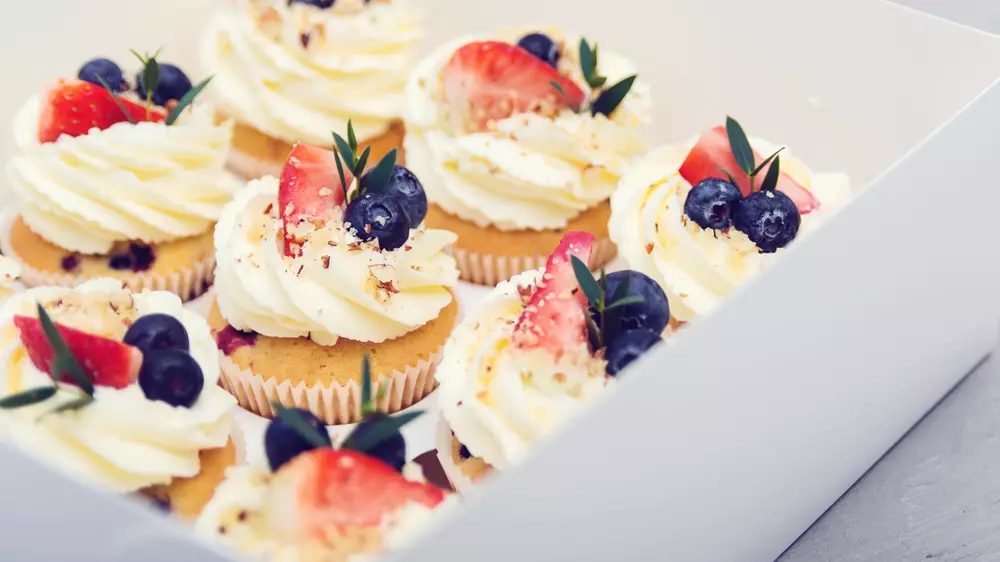 cupcakes in una scatola condita con frutta e glassa