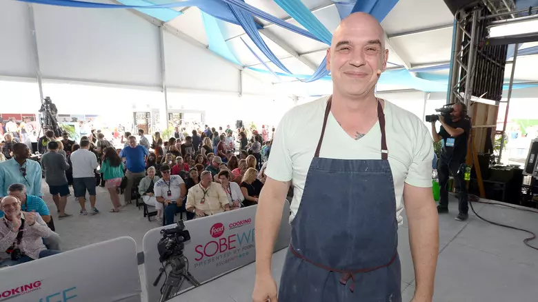 Michael Symon smiler i et blåt forklæde