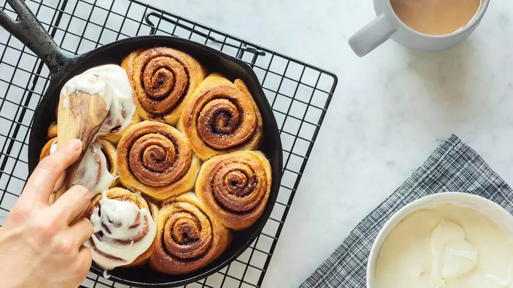 Vrou versier 'n pan kaneelrolletjies