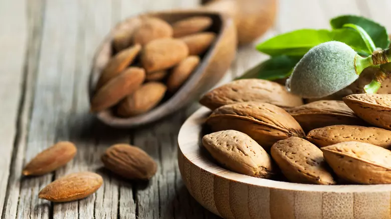 Almond di atas meja kayu dalam mangkuk