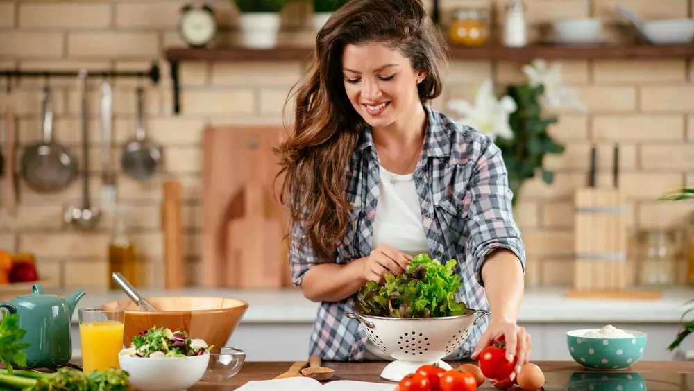 Femme faisant de la salade dans la cuisine à domicile